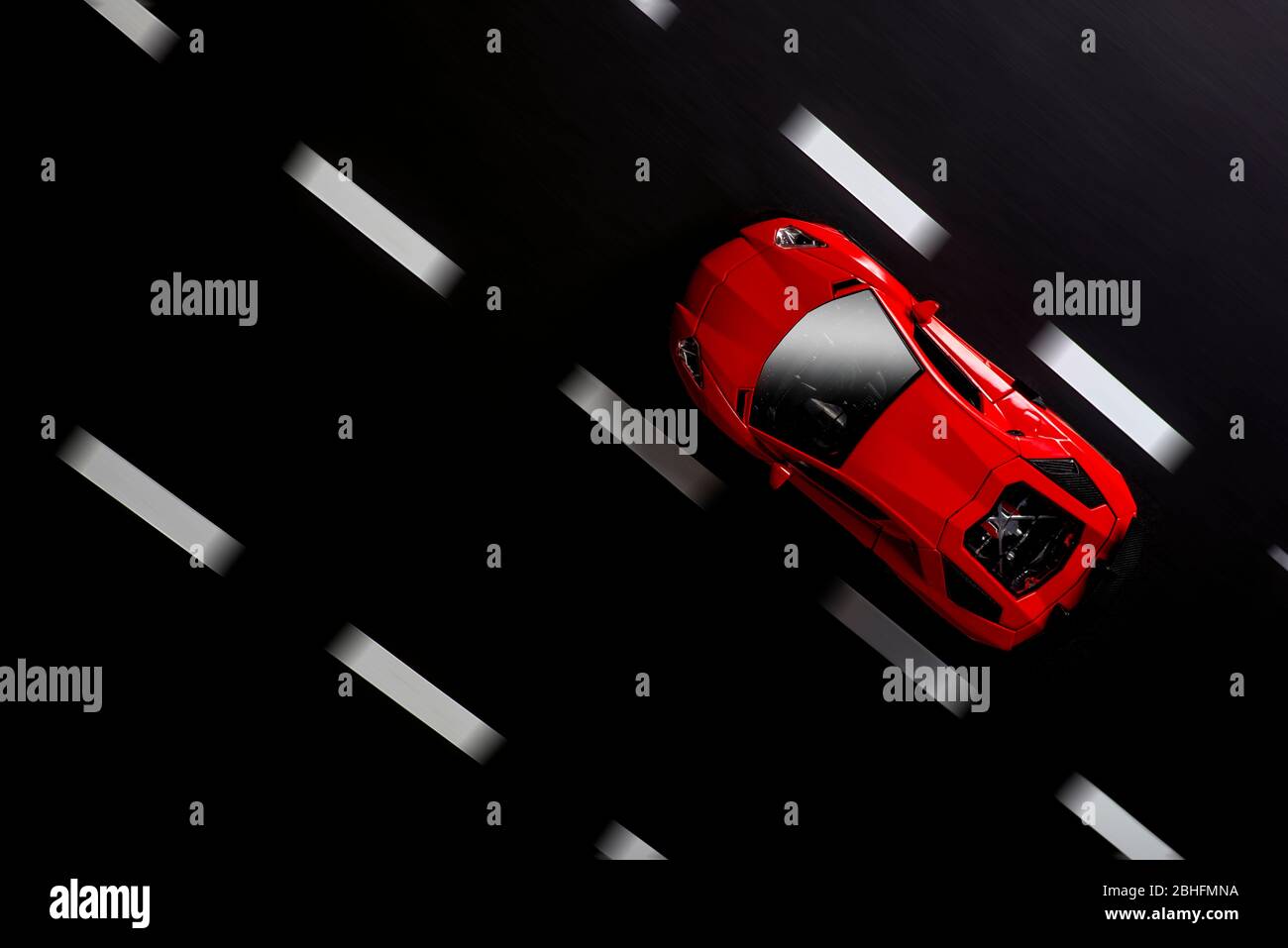 Top view of a red sports car on an asphalt background with road lanes ...