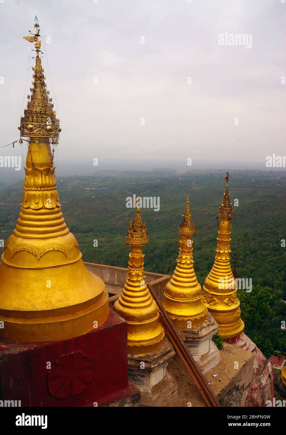 Gold-hued stupas atop Mount Popa pilgrimage site, with Myanmar's lush ...