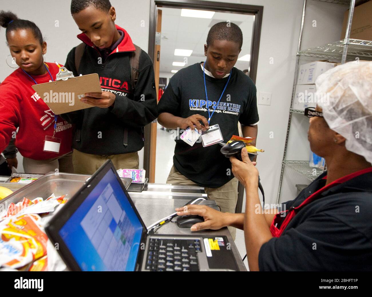 Cafeteria worker uses hand-held scanner to read barcode information on ...