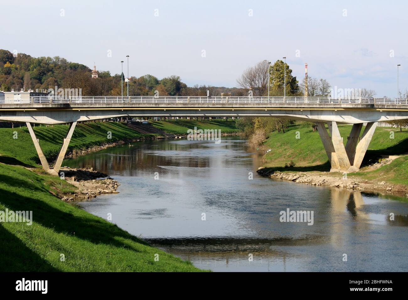 Concrete bridge over local river with low water level and visible rocks ...