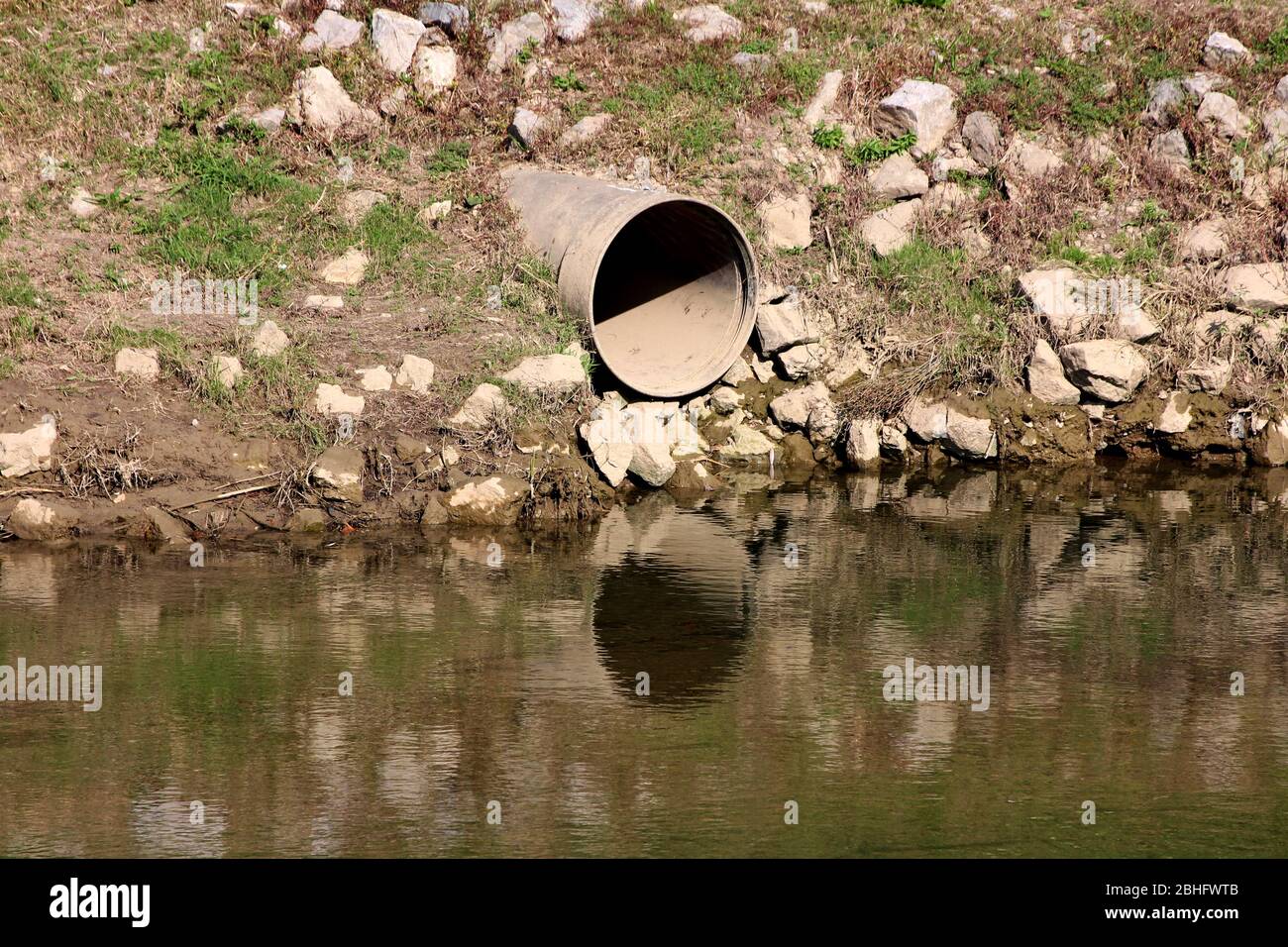 Large diameter storm drain concrete pipe exit surrounded with dirt ...