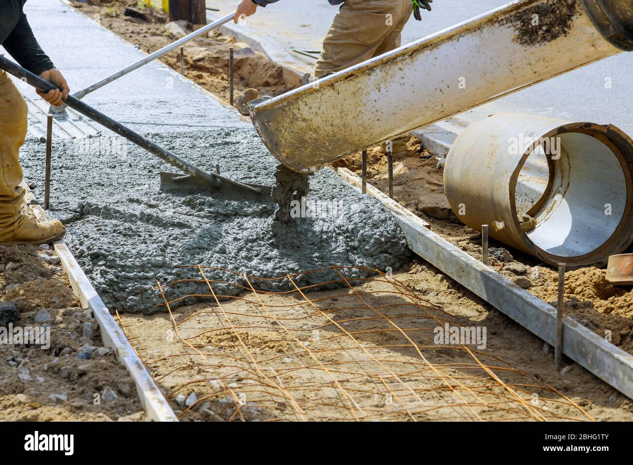 Cement truck mixer pouring fresh concrete on reinforced cement sidewalk ...