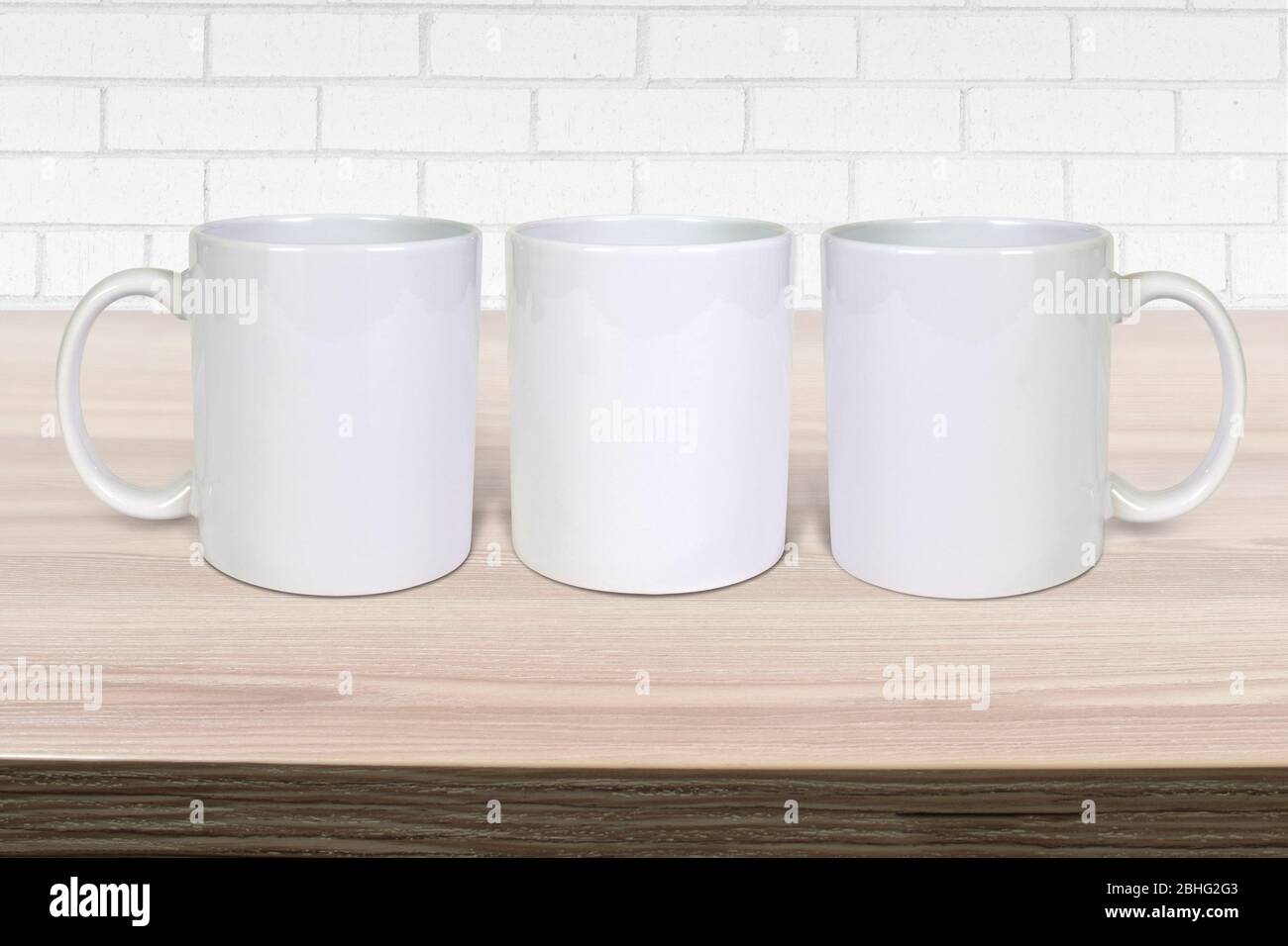 Three 11 ounce coffee mugs chilling on a light wood table Stock Photo ...