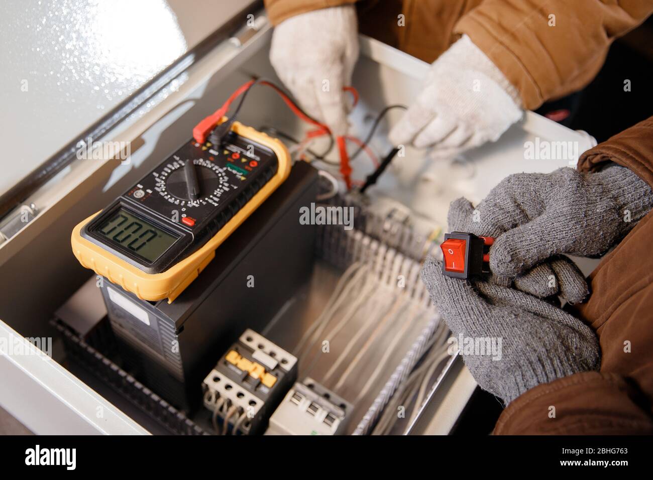 Master electrician checks electrical panel with multimeter for short ...