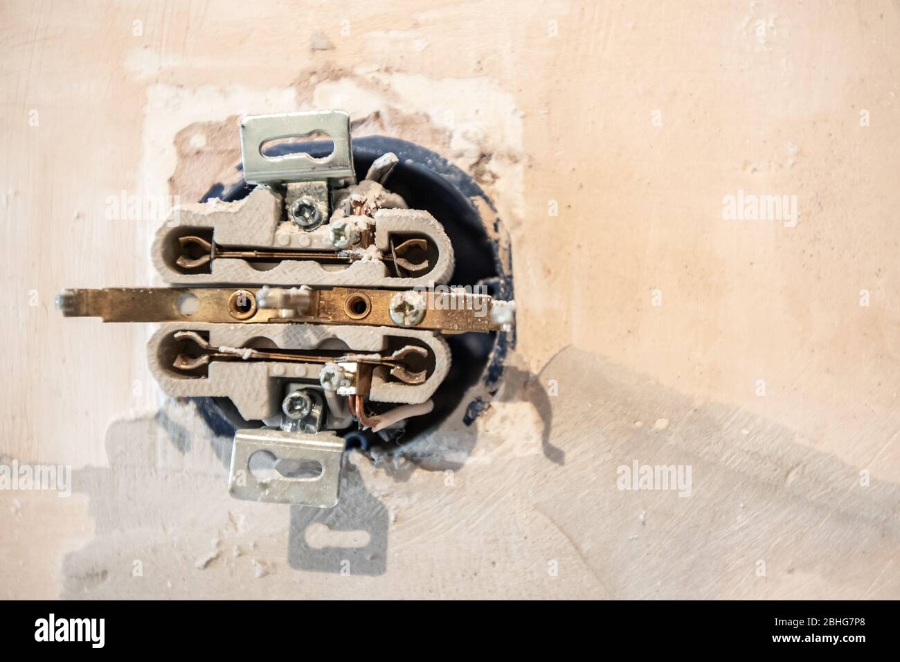 Disassembled electrical outlet in detonation wall with bare wires and ...