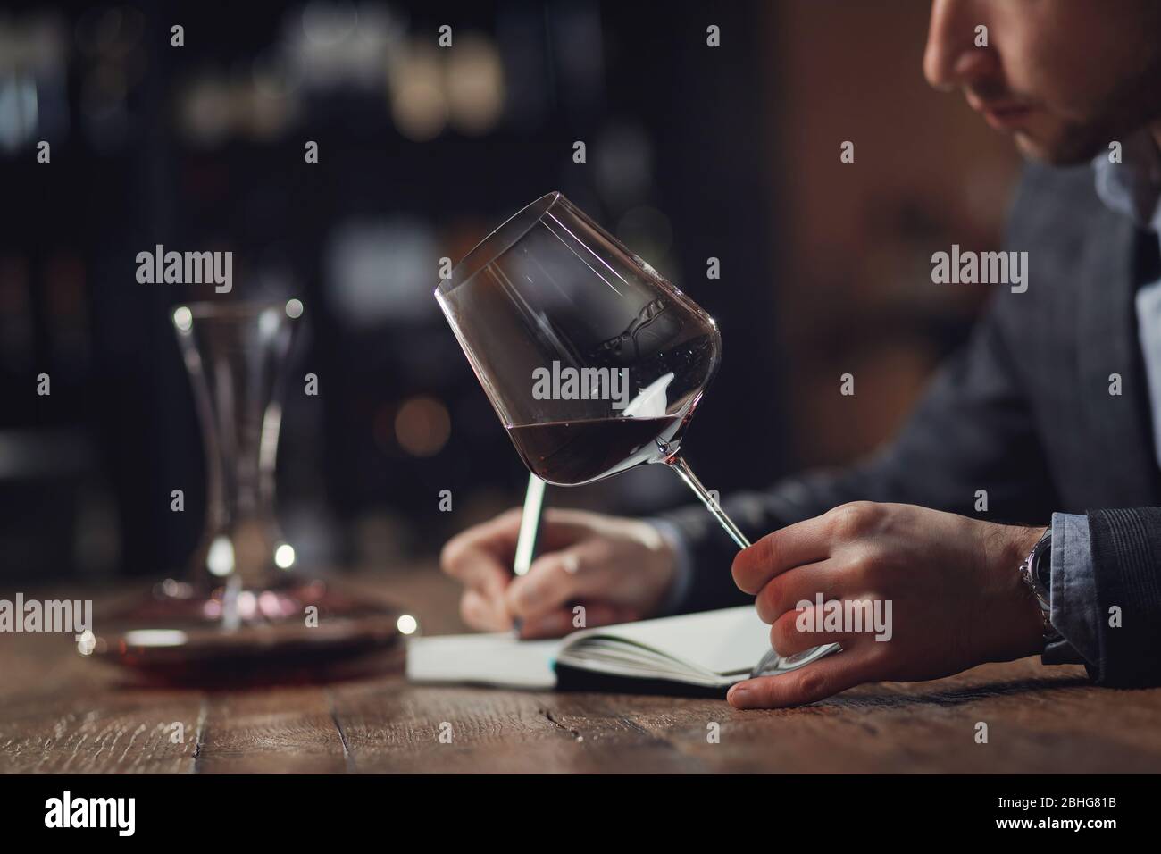 Sommeliers male hold glass red wine tasting and making notes ...
