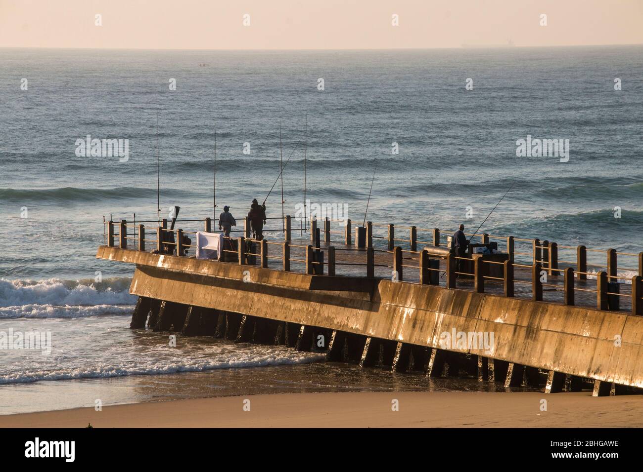 Fishermen fishing off concrete pier in indian ocean, Durban Stock Photo ...