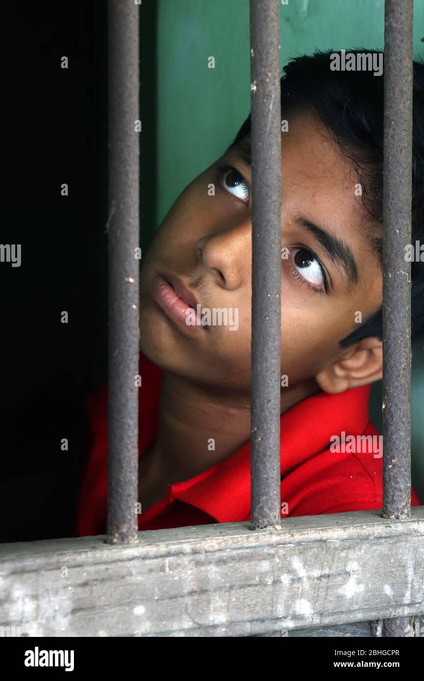 Portrait of a sad innocent child looking out the window. Sad boy looks ...