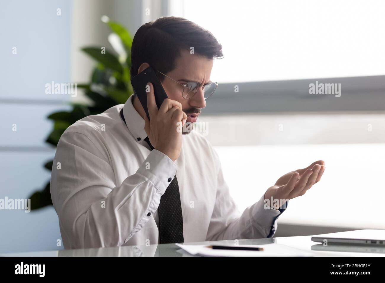 Frustrated businessman angry over bad news message talking on ...