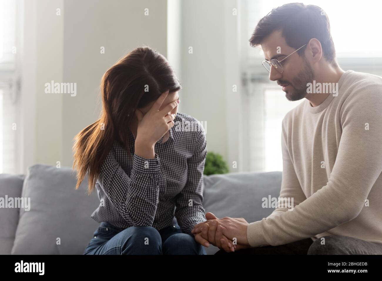 Handsome husband comforting wife, holding hands, showing support Stock ...