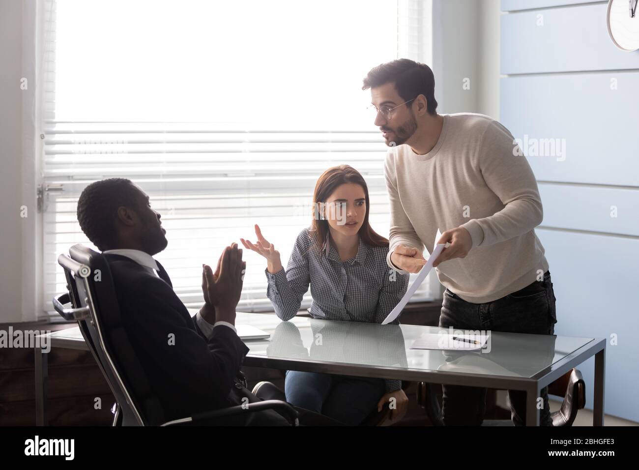 Angry man pointing an error in document to employee Stock Photo - Alamy