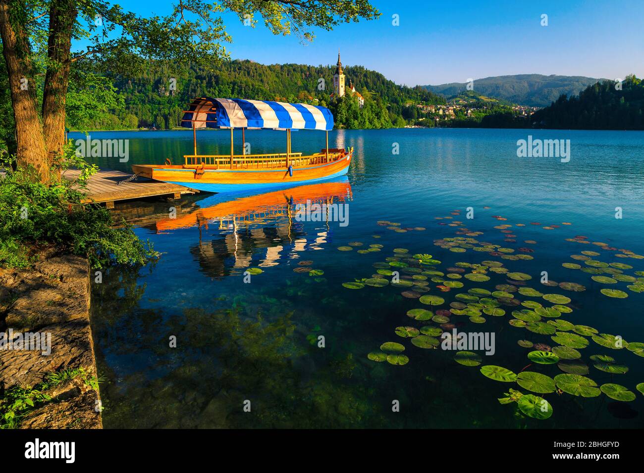 Traditional touristic wooden Pletna boat anchored at the pier on the ...
