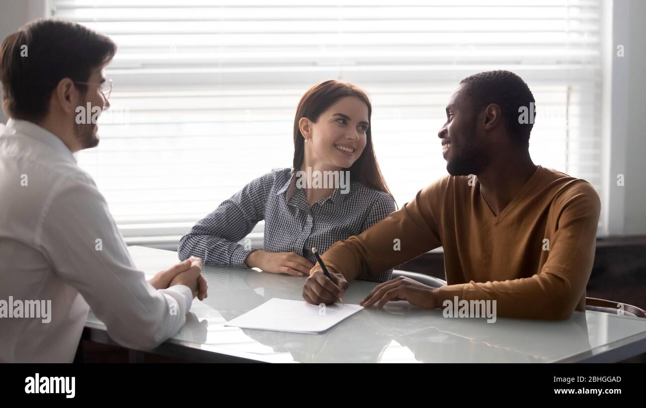 Successful couple, diverse man and woman discuss terms of contract ...