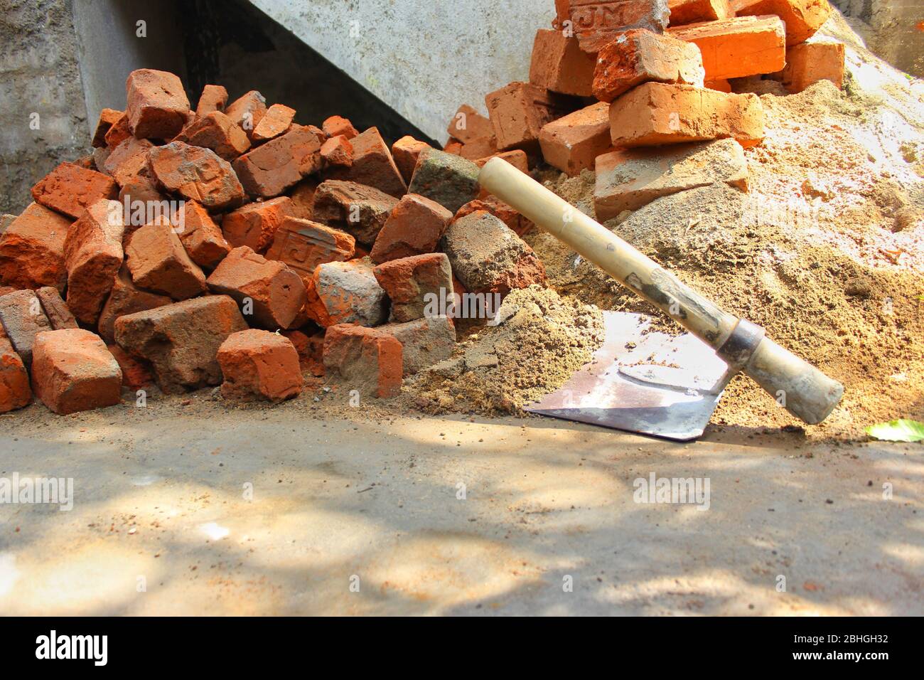 Stack of red clay Bricks and sand Shovel on filed construction site ...