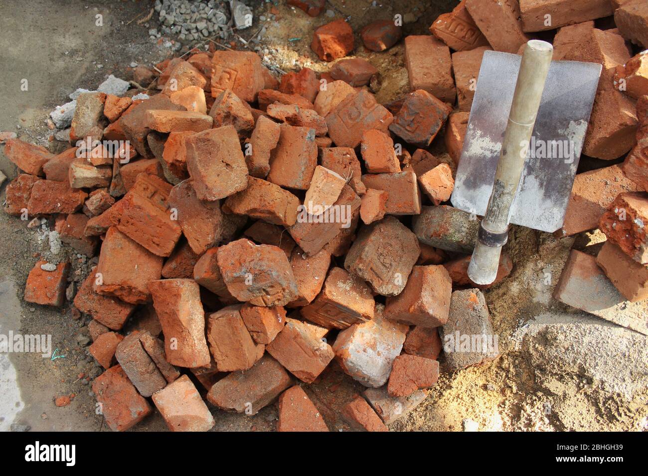 Stack of red clay Bricks and sand Shovel on filed construction site ...