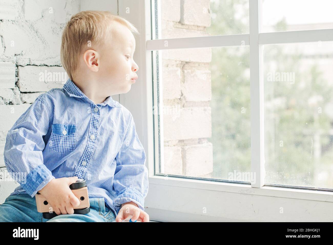 Little child boy staying home and looking out window Stock Photo - Alamy