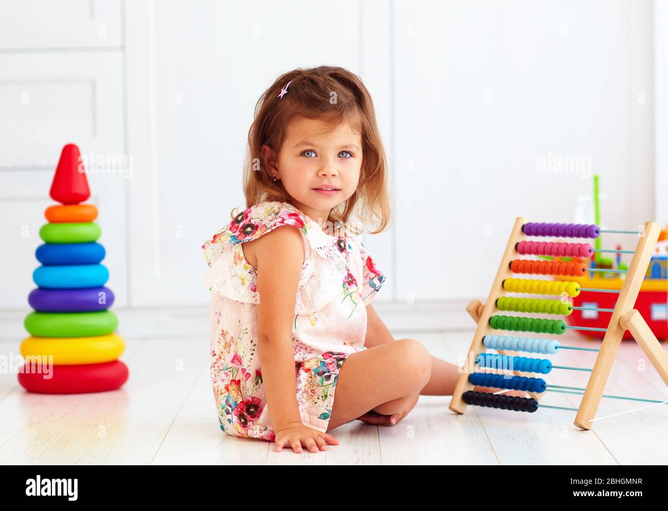 cute little baby girl playing with wooden toy on the floor Stock Photo ...
