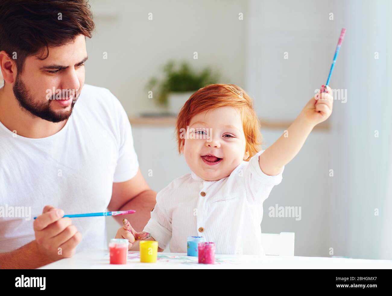 happy little baby artist drawing with colorful paints and father at ...