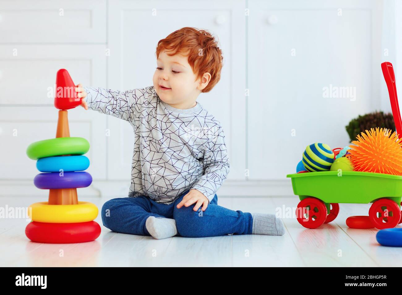 happy toddler baby boy sorting colorful rings on pyramid Stock Photo ...