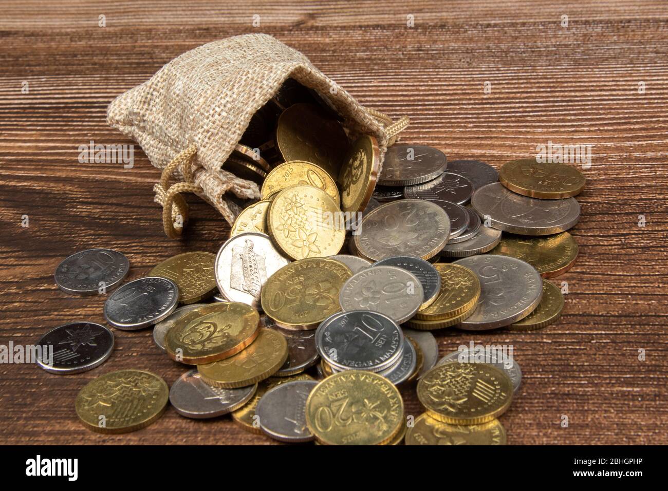 sack bag with Malaysia Ringgit coin on wooden table.- Saving Concept ...