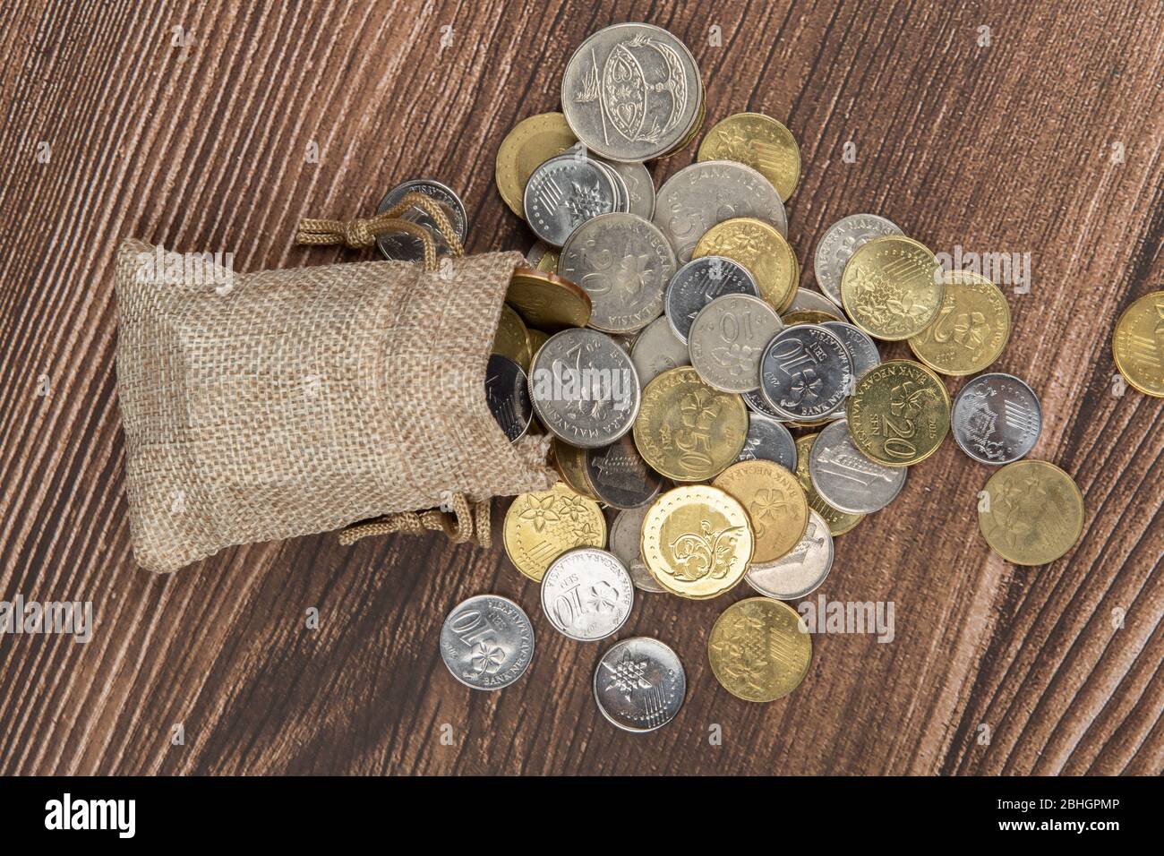 sack bag with Malaysia Ringgit coin on wooden table.- Saving Concept ...