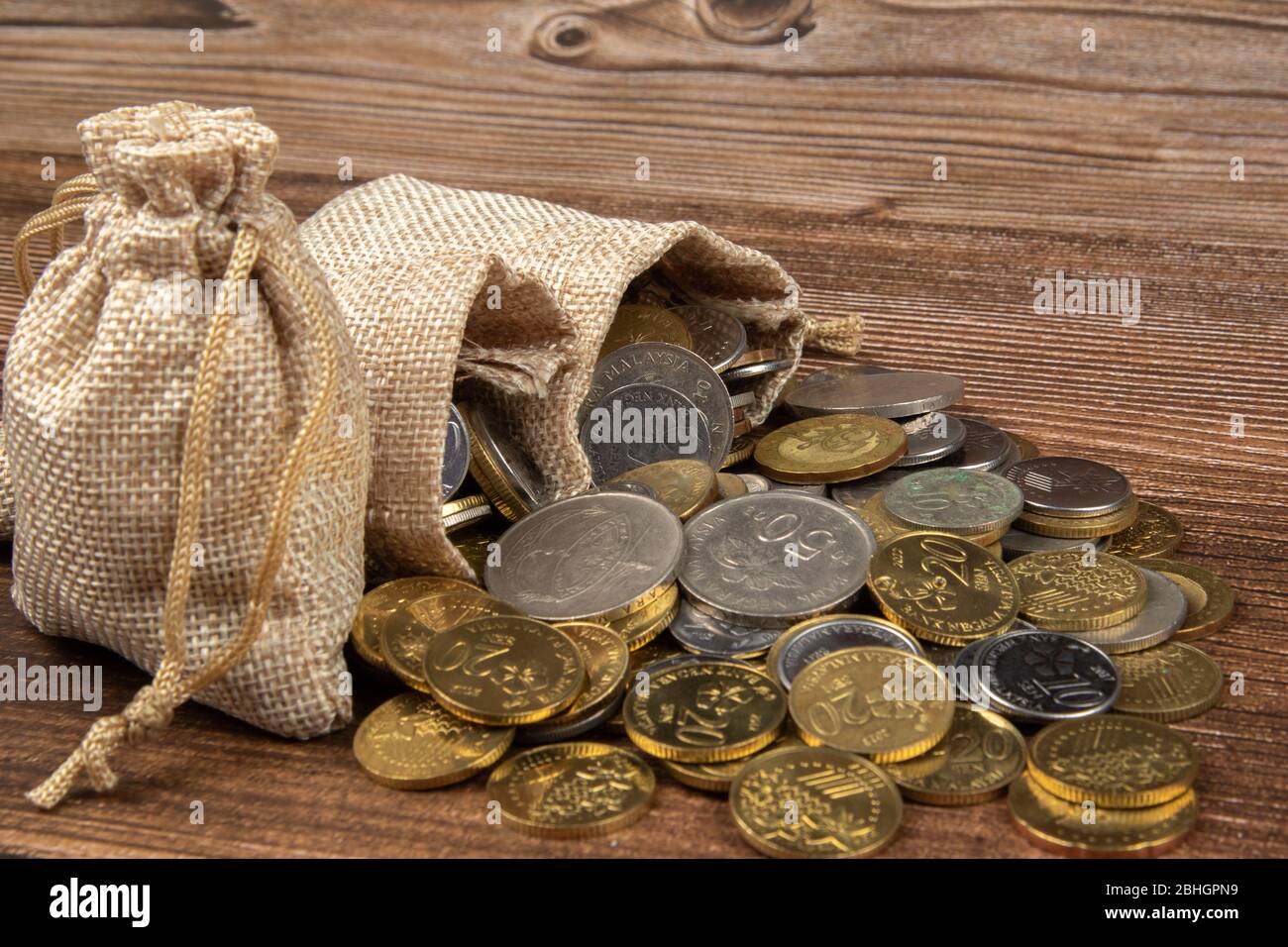 sack bag with Malaysia Ringgit coin on wooden table.- Saving Concept ...