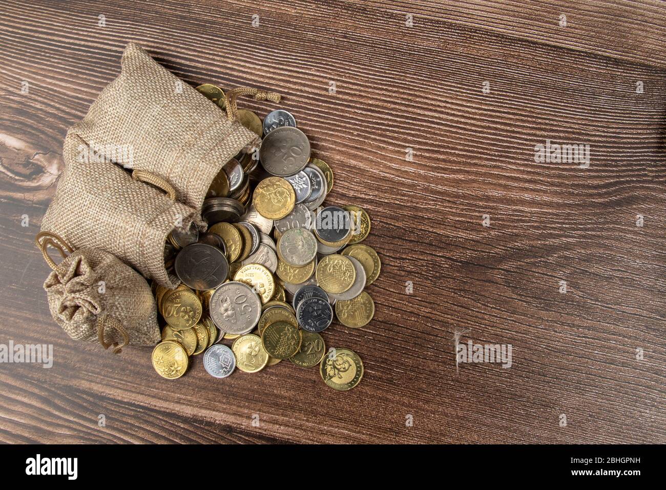 sack bag with Malaysia Ringgit coin on wooden table.- Saving Concept ...