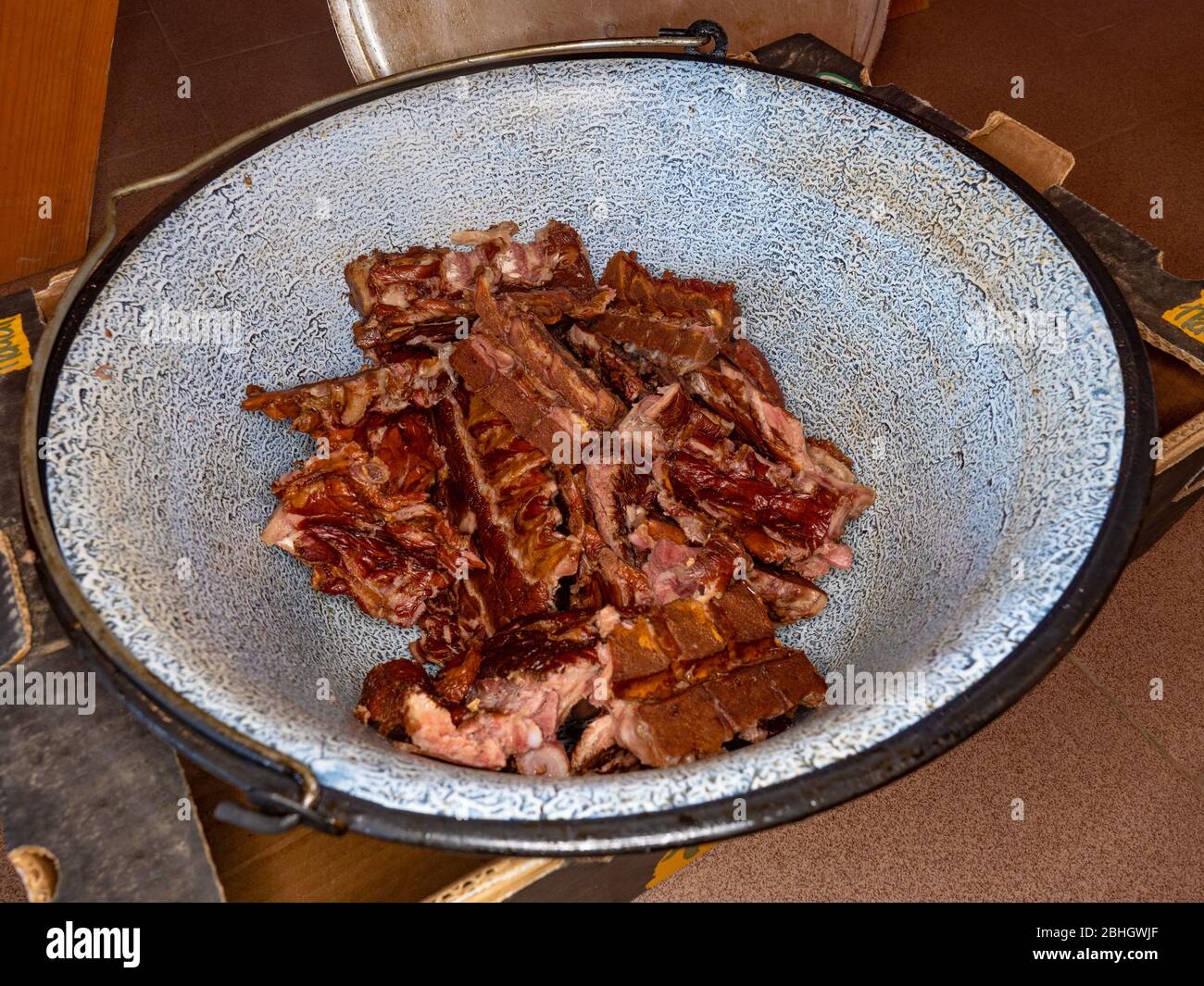 Meat broth in cauldron with cooked meat. Spilling the broth from the ...