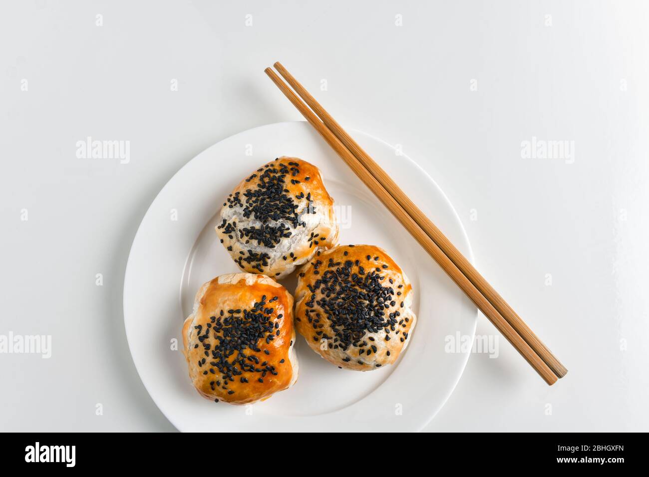 Chinese red bean paste cakes and chopsticks on ceramic plate, isolated ...