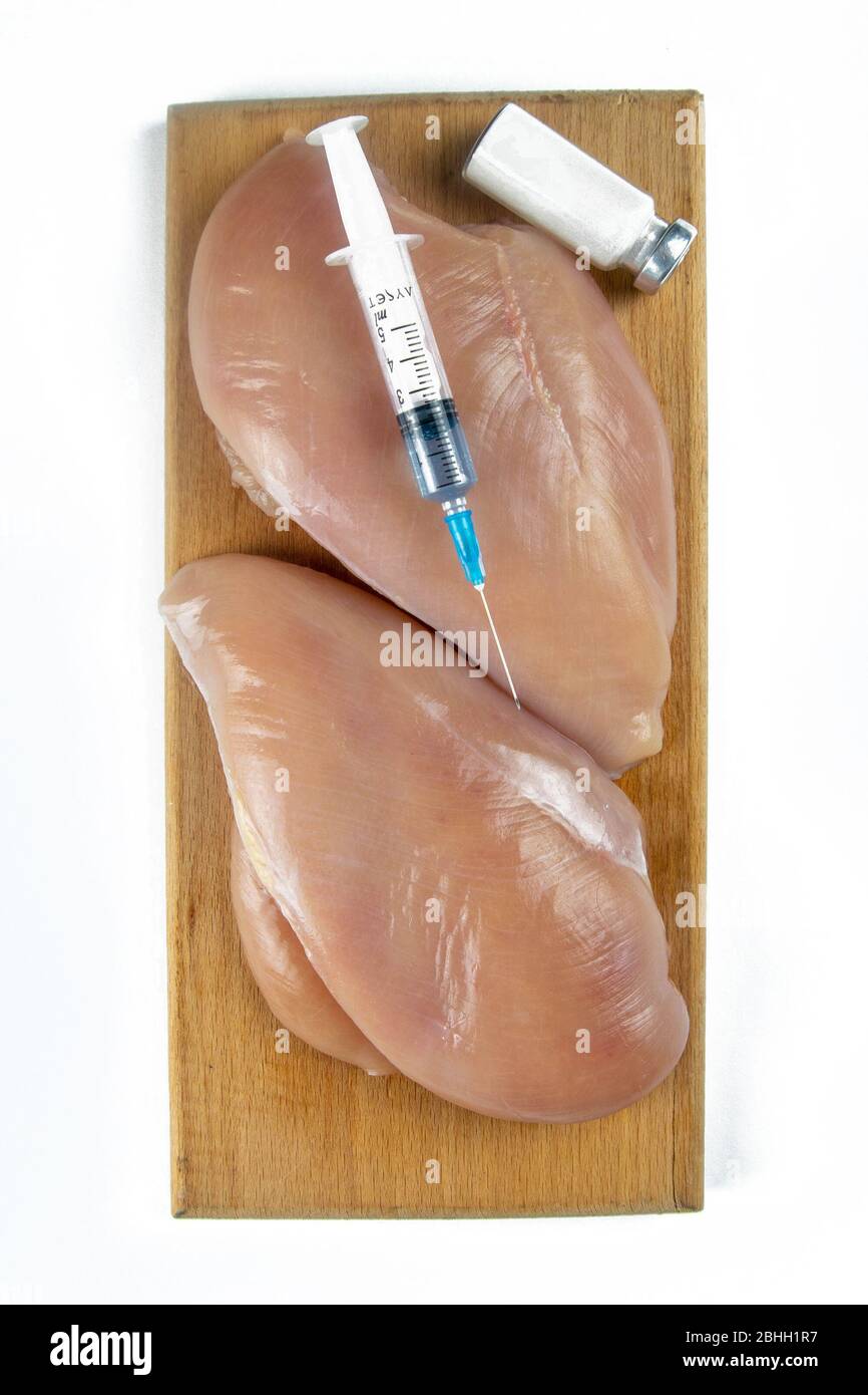 Syringe with liquid being injected to a piece of meat. Conceptual ...
