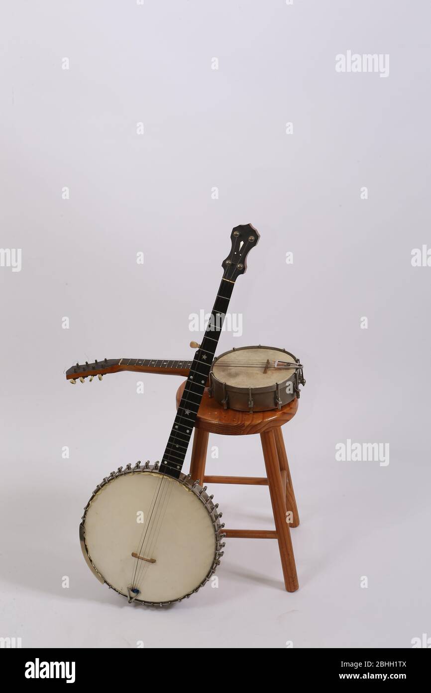 A banjo resting against a stool with a banjalele Stock Photo - Alamy