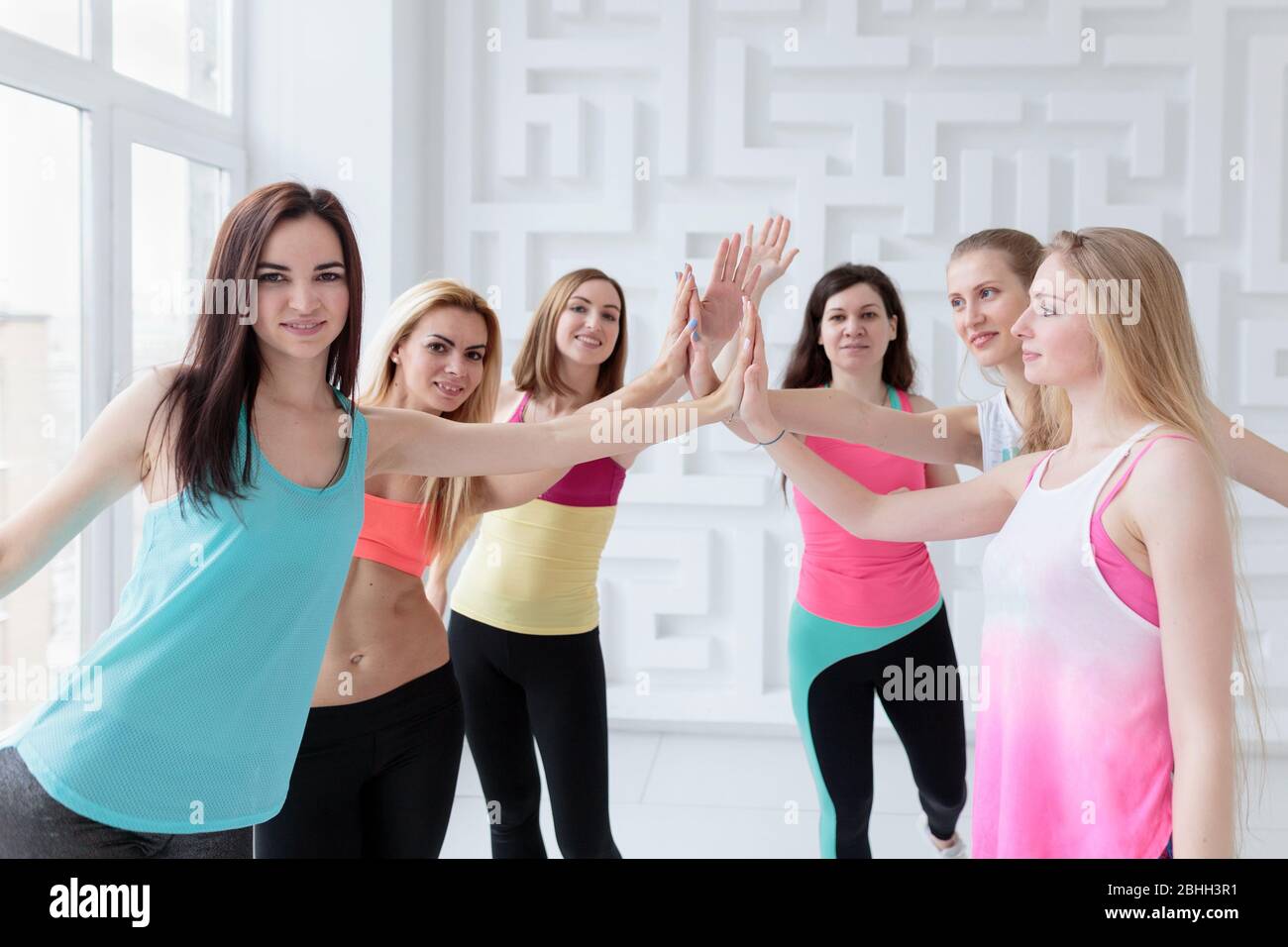 Group of fit women joining hands after having dance fitness class Stock ...