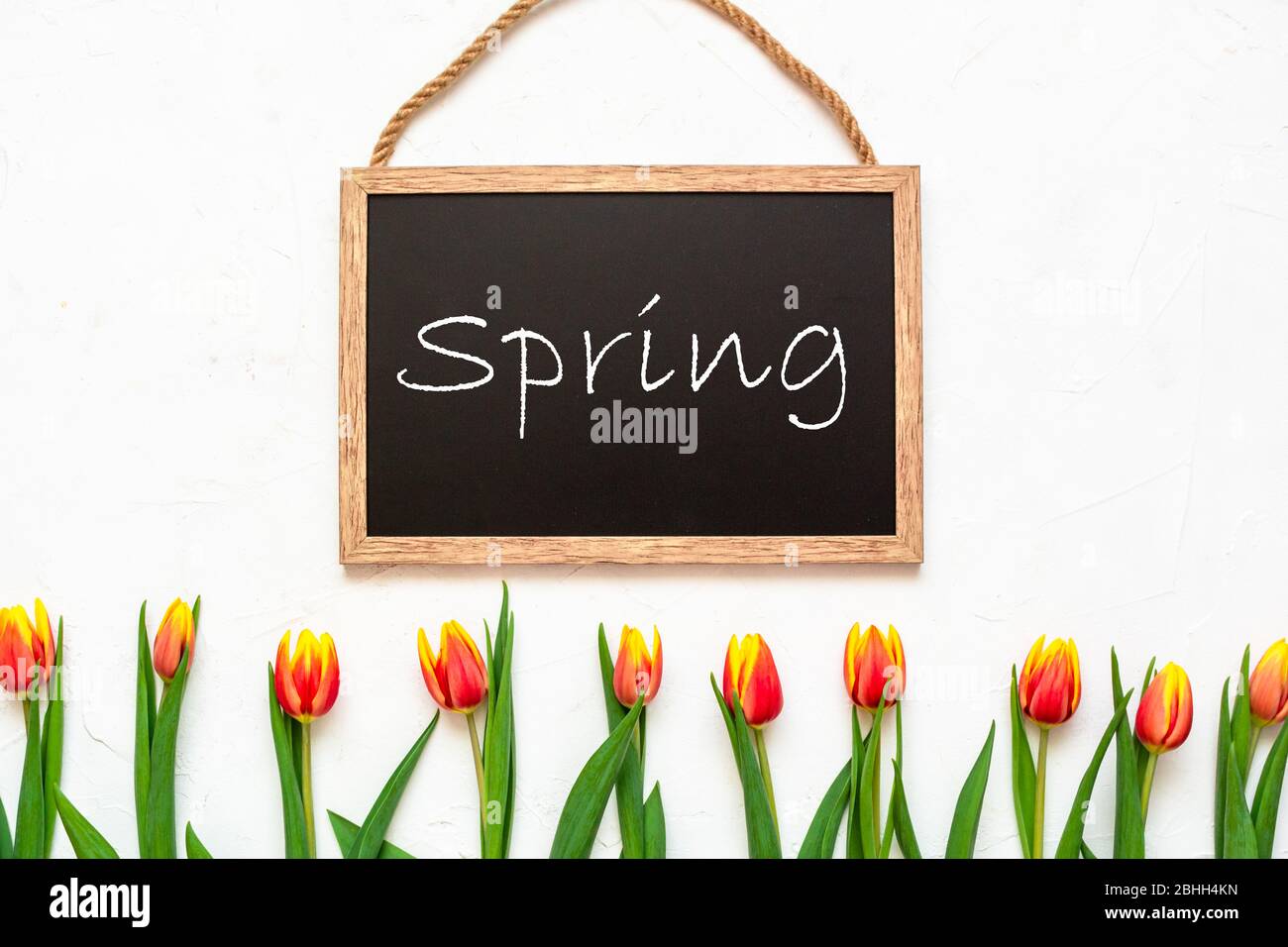 Spring text on a blackboard and spring tulips Stock Photo - Alamy