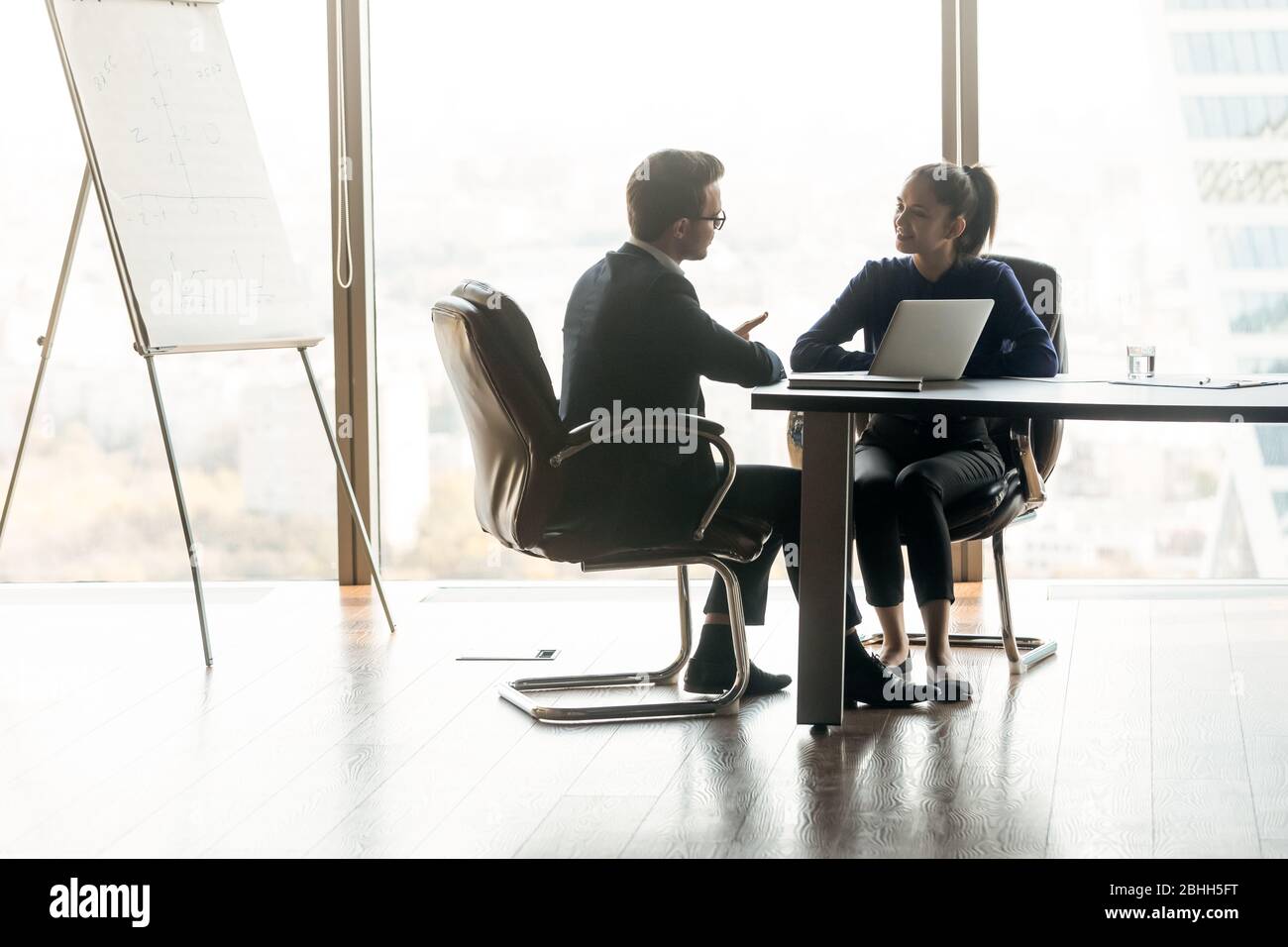 Two business partners discussing project strategy in modern office ...