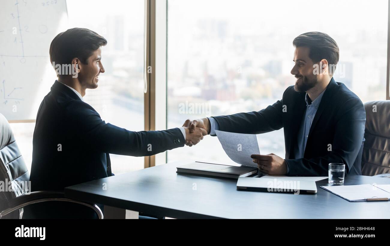 Smiling satisfied hr manager shaking successful candidate hand after ...