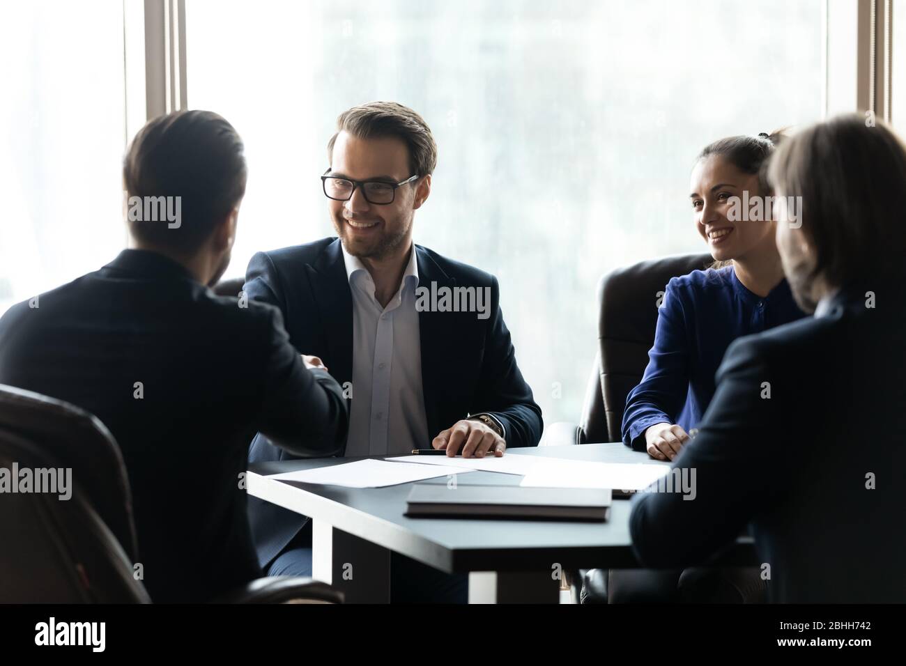 Two confident businessmen shaking hands on group negotiations Stock ...