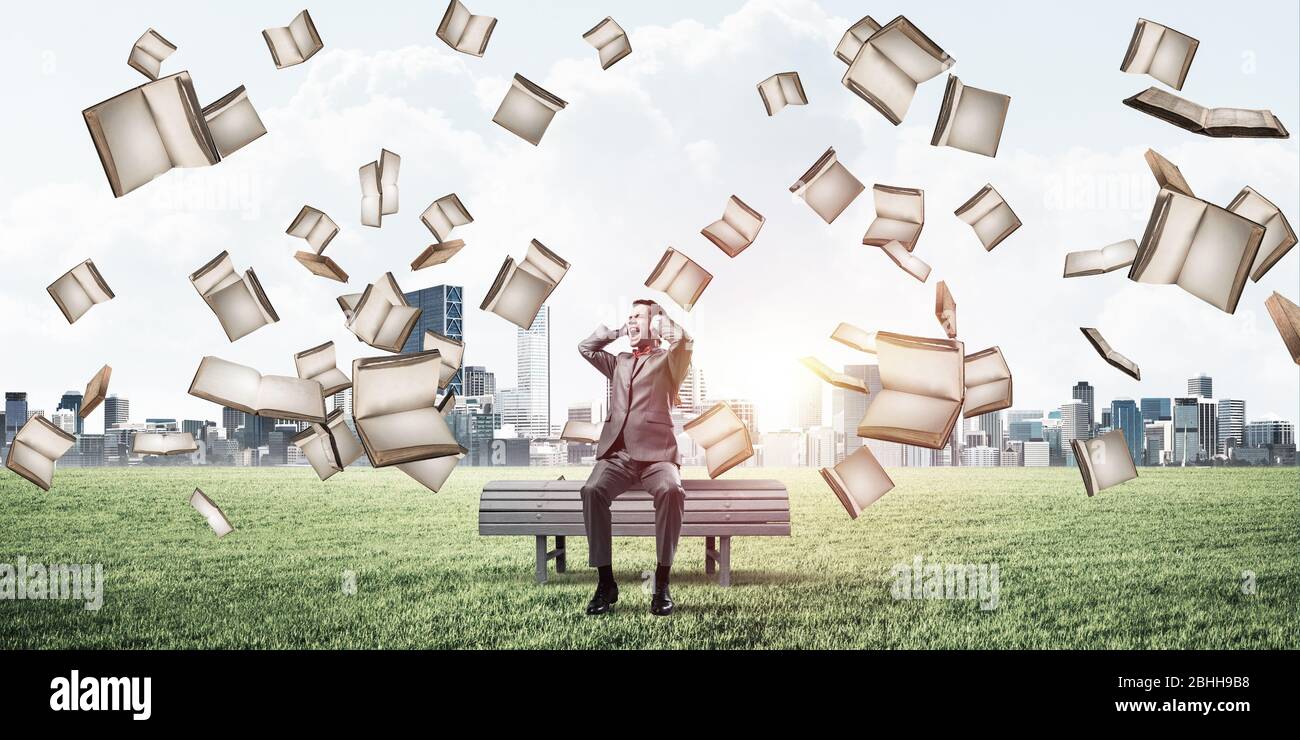 Many old books falling from above and student guy sitting on bench ...