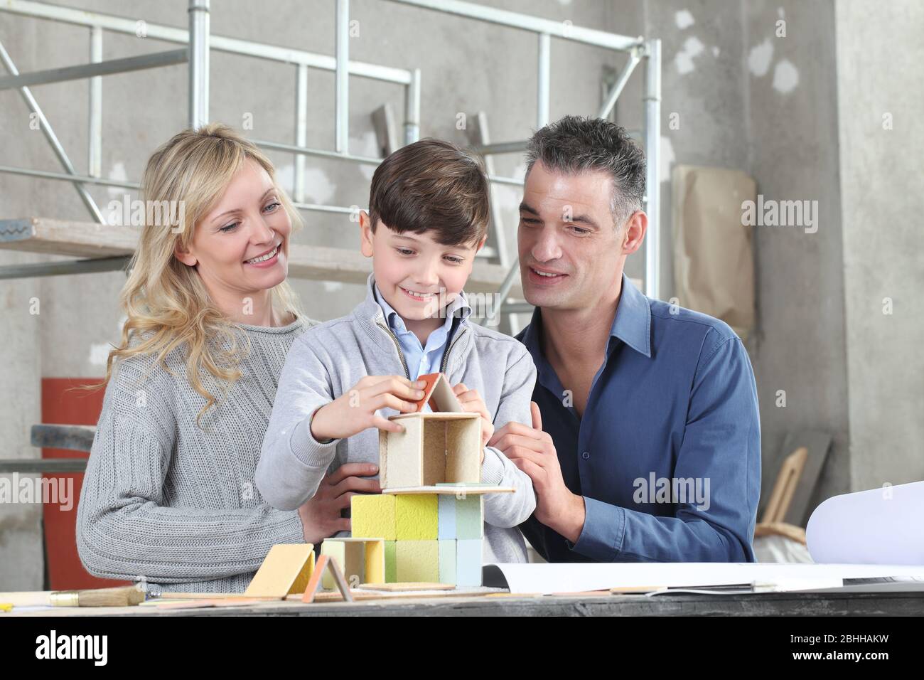 Happy children and his family playing building a house with ...