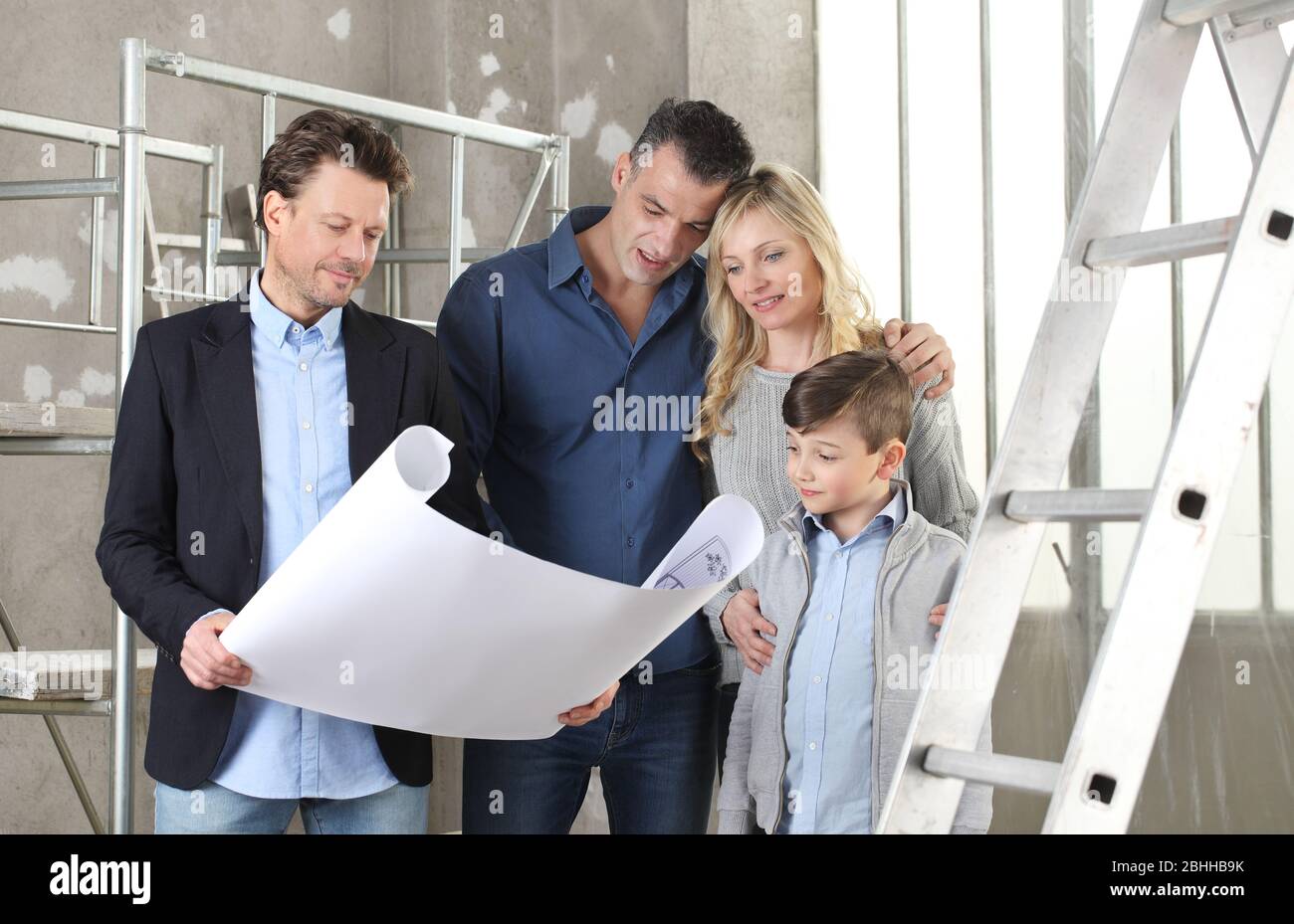 Architect showing house design plans to a family with child. Meeting at ...