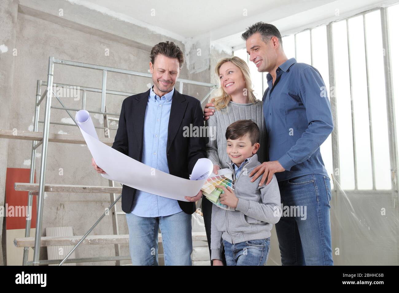 Architect showing house design plans to a family with child. Meeting at ...