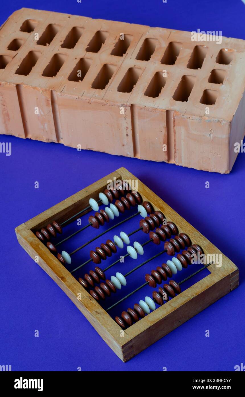 Brick and wooden abacus on a blue background. New red brick and screw ...