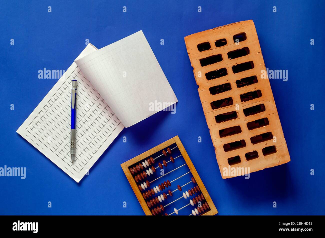 Brick, blank invoice and wooden abacus on a blue background. New red ...