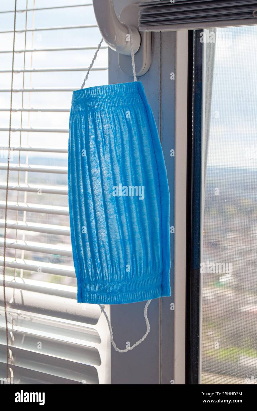 medical mask hanging after washing on a balcony window Stock Photo - Alamy