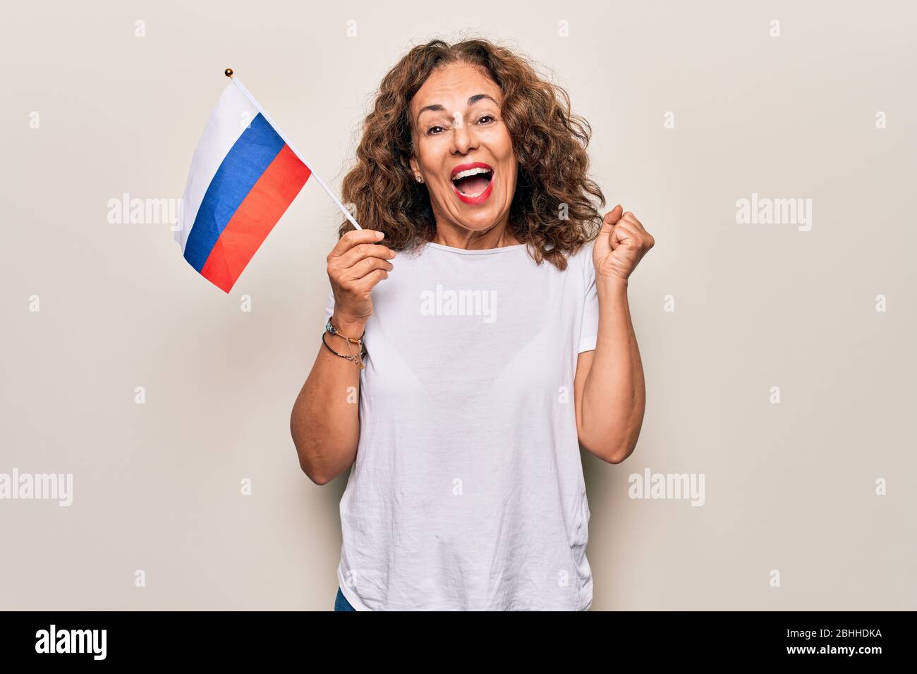Middle age beautiful tourist woman holding russian flag over isolated ...