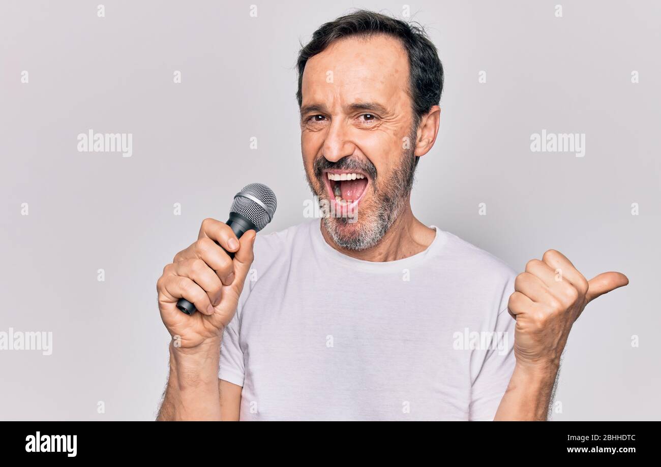 Middle age handsome singer man singing using microphone over isolated ...