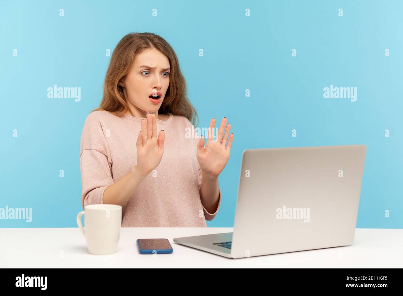 I'm scared! Frightened woman with shocked expression raising hands in ...