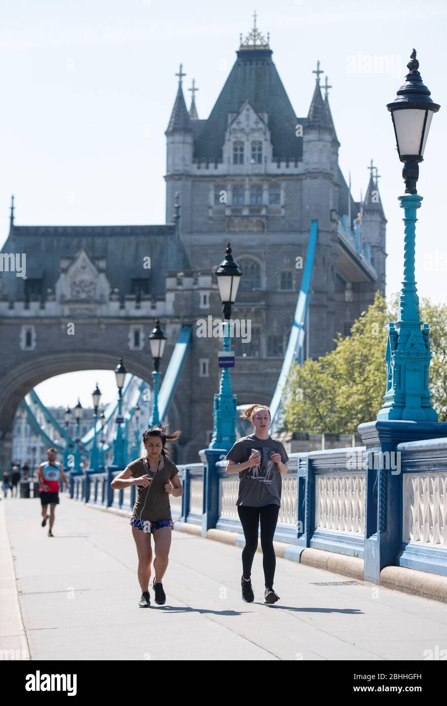 Runners pass over Tower Bridge, in central London, on the course of the ...