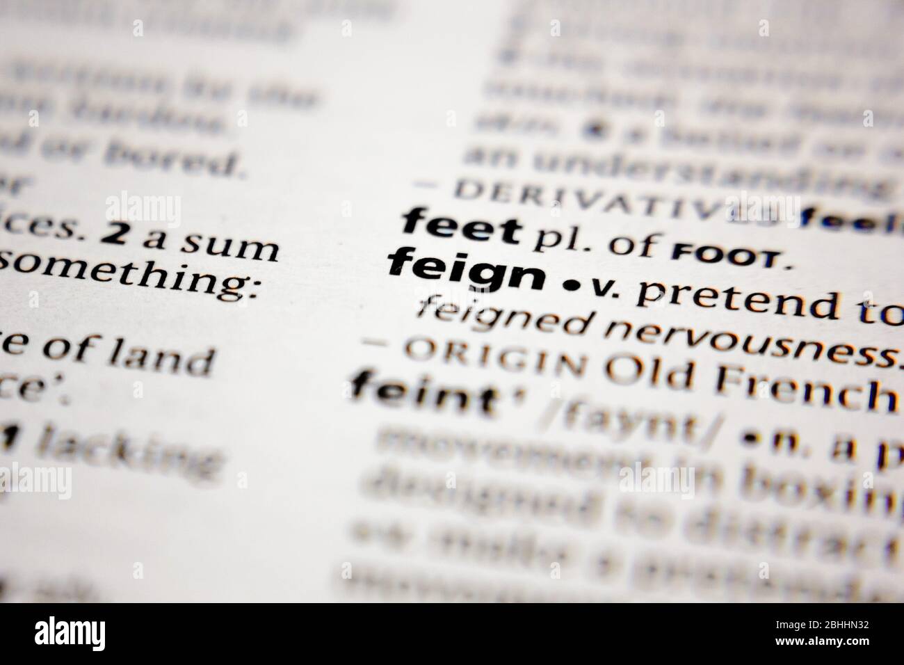 Word or phrase feign in a dictionary Stock Photo - Alamy