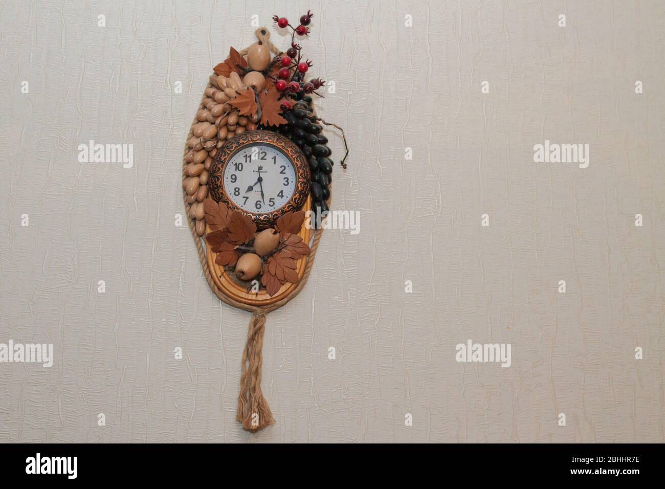 Wall mounted wooden clock hanging on the wall Stock Photo - Alamy
