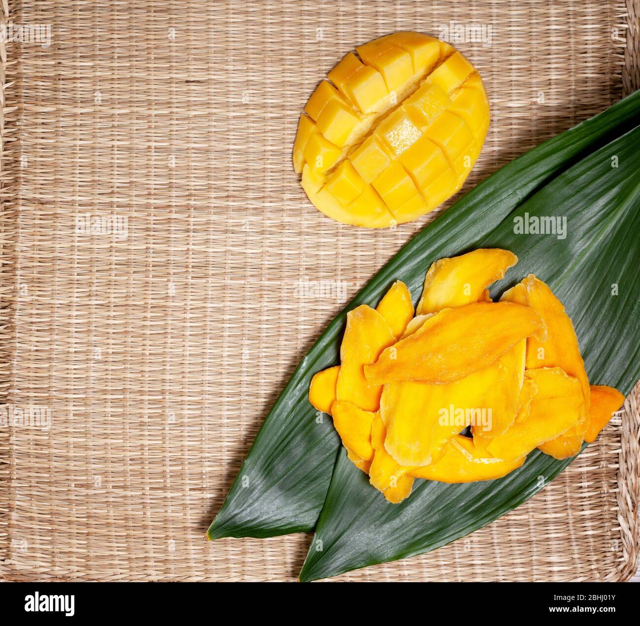 pieces of dried mango, fresh mango on a straw background. view from ...